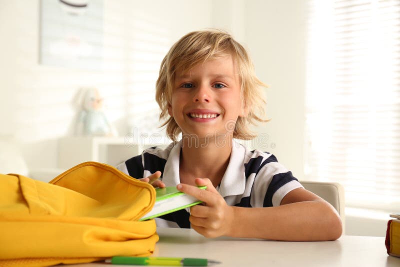 Little Boy Taking Book from Backpack at Table Indoors. Doing Homework ...