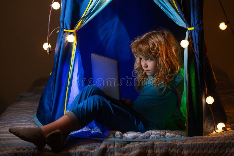 Little Boy in Tent Bed Looking at the Laptop at Night. Little Hacker ...