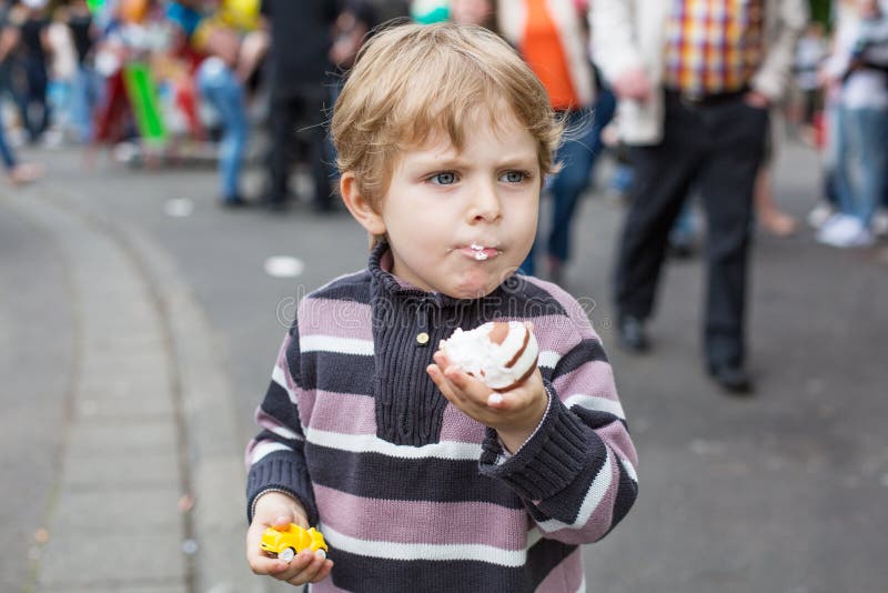 Little Boy of Three Years Eating at a Funfair, Outdoors Stock Image ...