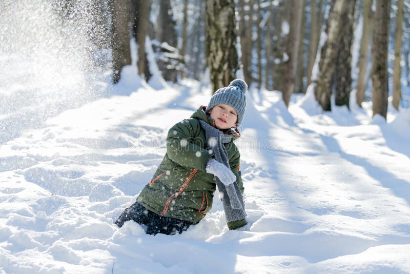 Little Boy Throwing Snow in the Woods in Winter Stock Photo - Image of ...