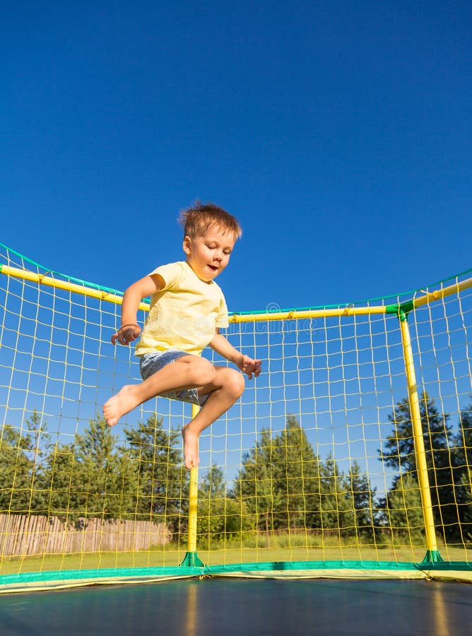Little boy on a trampoline stock image. Image of cute - 77212705
