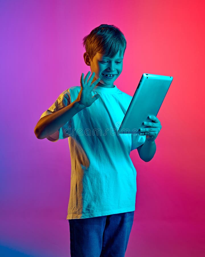 Little Boy Using Tablet and Waving Hello during Online Lesson in Neon ...