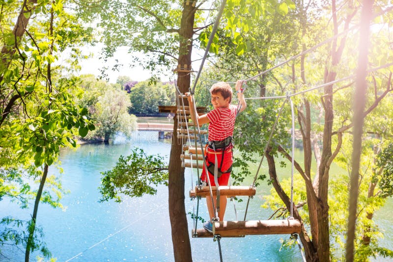 Little Boy Walk on the Rope Bridge between Trees Stock Photo - Image of ...
