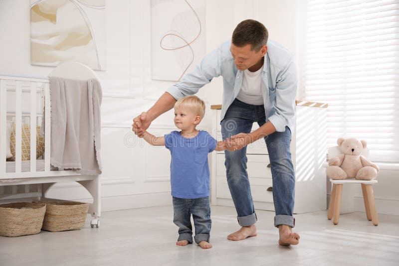 Little Boy Walking with Father`s Help in Nursery Stock Photo - Image of ...