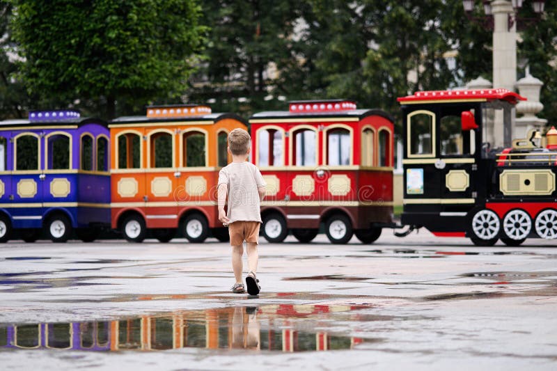 Little Boy Walking Towards a Colorful Toy Train Stock Image - Image of ...