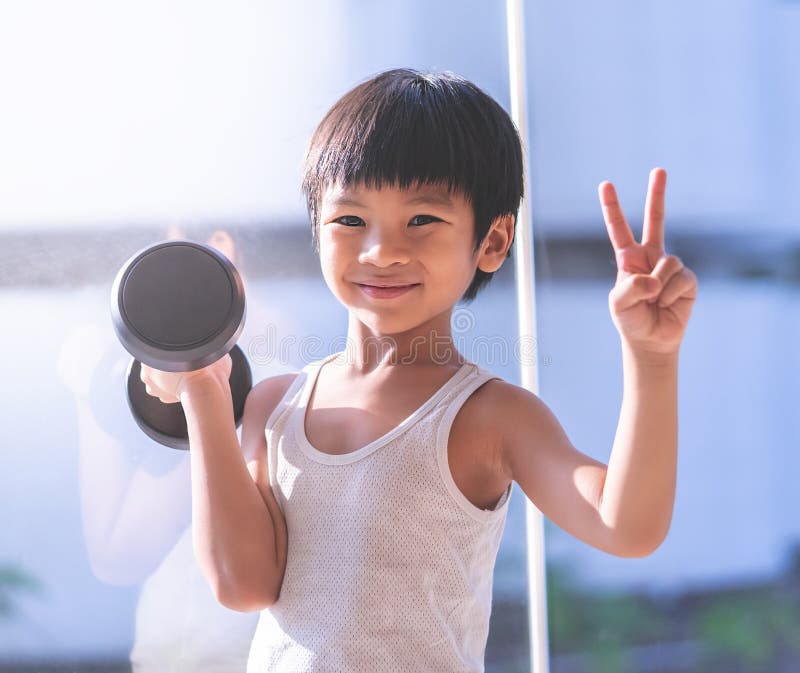 Boy is Working Out with Dumbbell by the Windows City Stock Image ...