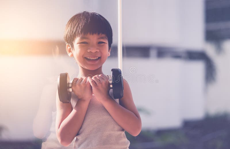 Boy is Working Out with Dumbbell by the Windows City Stock Photo ...