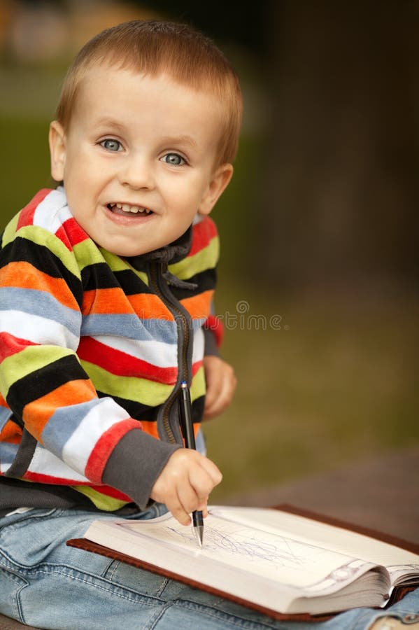 Little boy writes with pen stock image. Image of notepad - 28246631