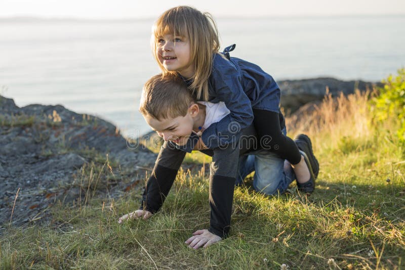 Little Brother and Sister Playing in the Grass on Sunset in Summer ...