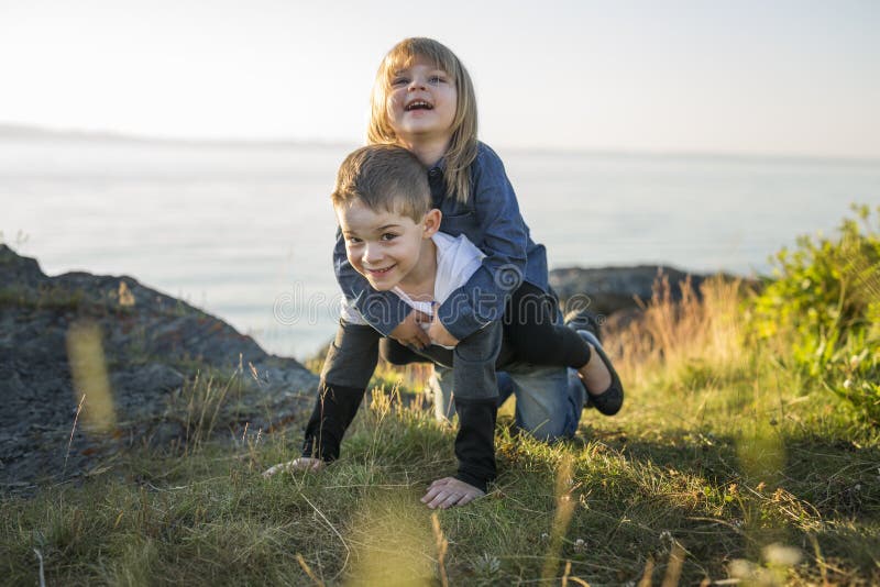 Little Brother and Sister Playing in the Grass on Sunset in Summer ...