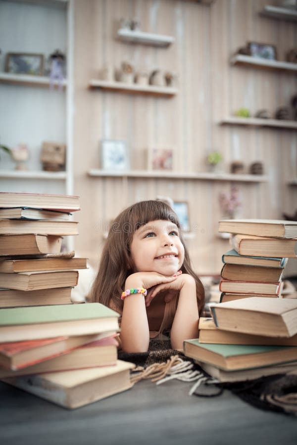 Little Cheerful Girl with Stack of Books in Library; Stock Image ...
