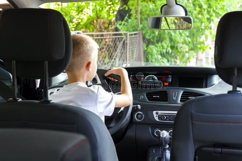 Little Child Boy Behind the Steering Wheel of a Car Stock Photo - Image ...