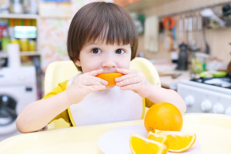 Little child eats orange stock image. Image of fruit - 52695733