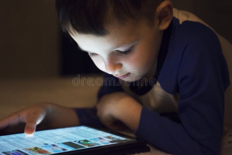 Little Child Kid Using Tablet Technology In Bed By Night At Home Stock ...