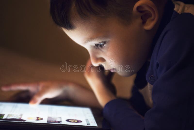Little Child Kid Using Tablet Technology in Bed by Night at Home Stock ...