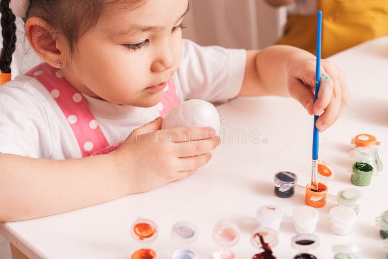 Little Child Paints Eggs with Different Colors Stock Image - Image of ...