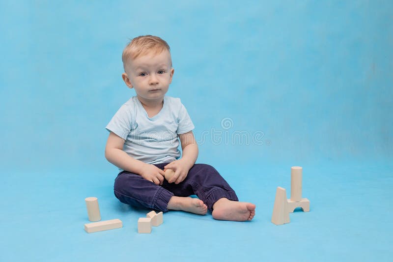 Little Cute Boy Assembling Constructor, Blue Background, Looking at ...