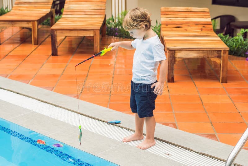 A Little Cute Boy is Catching a Toy Fish in the Pool Stock Image ...
