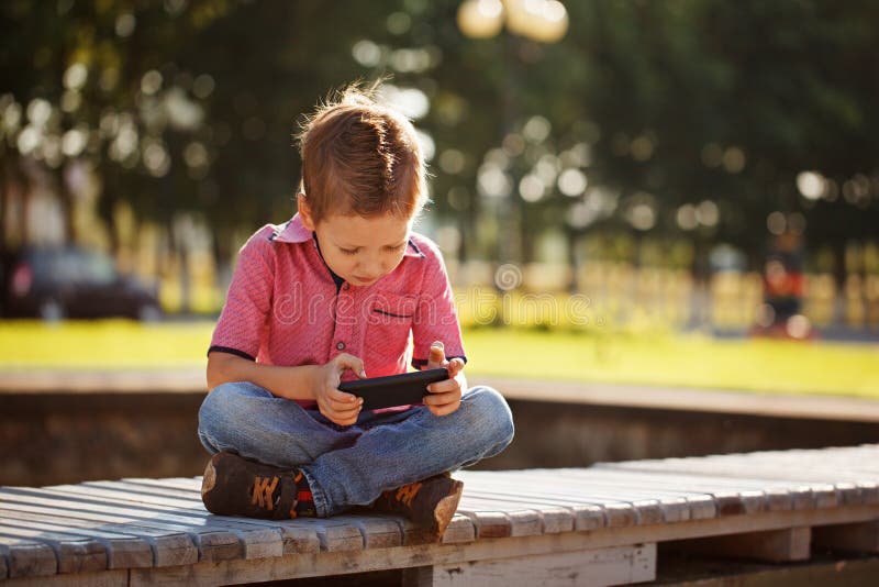 Little Cute Boy Playing in the Phone in Sunny Day Stock Photo - Image ...