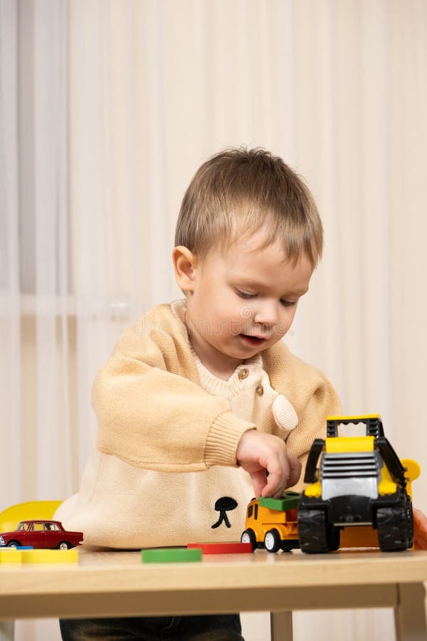 Little Cute Boy Playing with Toys while Sitting at Table Stock Photo ...