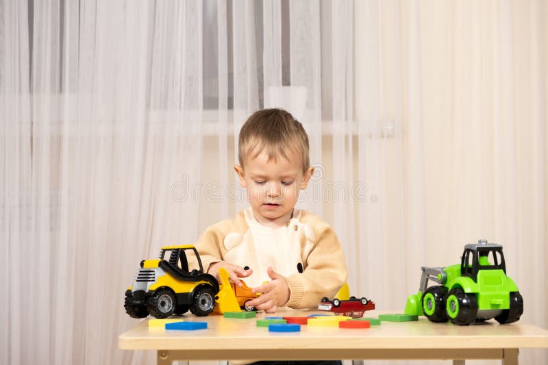 Little Cute Boy Playing with Toys while Sitting at Table Stock Image ...