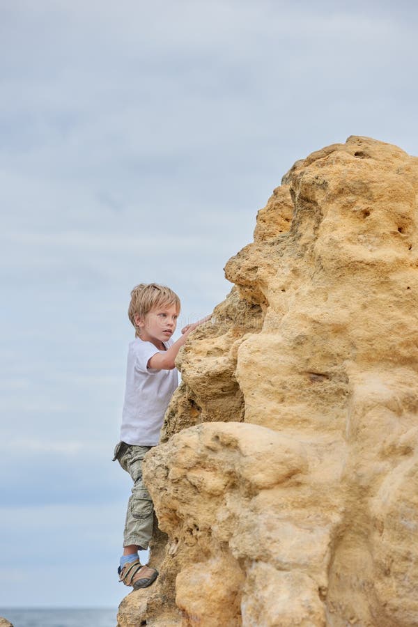 Boy playing with rocks stock photo. Image of beach, active - 115188648