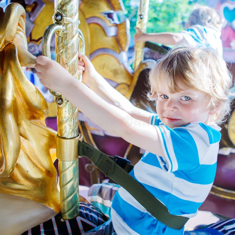 Little Cute Child during Carousel Ride, Enjoying and Having Fun Stock ...