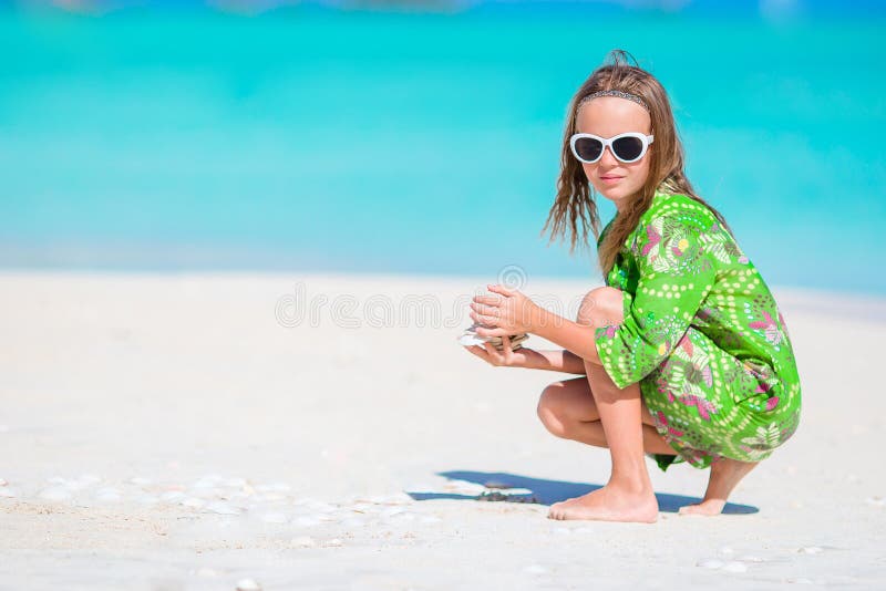 Little Cute Girl with Seashell in Hands at Tropical Beach. Adorable ... Little Cute Girl with Seashell in Hands at Tropical Beach. Adorable ...