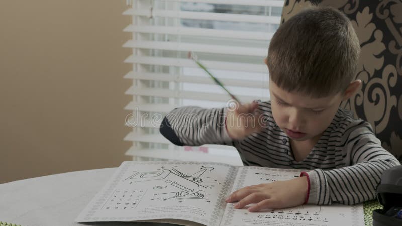Little Diligent Boy Studying His Homework at Home he Sits at a Table ...