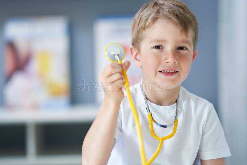 A Little Doctor with Stethoscope Smiling in Doctor`s Office Stock Photo ...