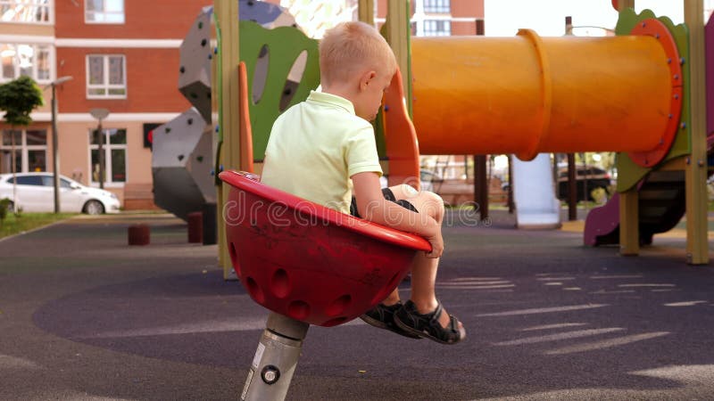 A Little Funny Boy is Spinning on an Interesting Carousel on a Modern ...