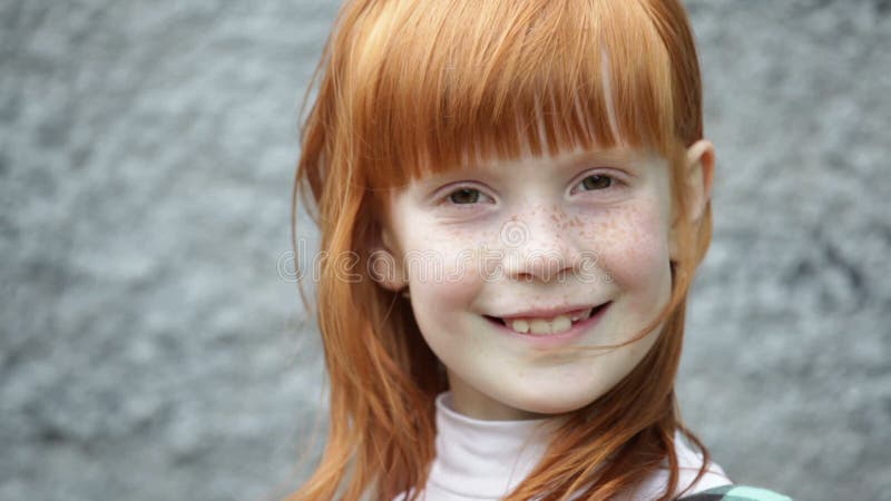 Happy Ginger Teenage Girl With Freckles Smiling Against White Wall