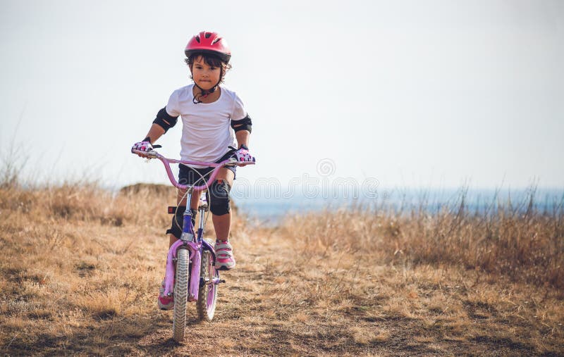 Little Girl with Biking at Sunset on the Hills Stock Photo - Image of ...