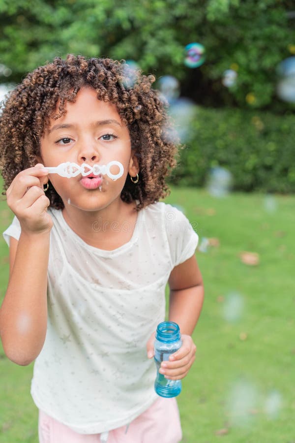 Little Girl Blowing Bubbles in Field Stock Photo - Image of bubble ...