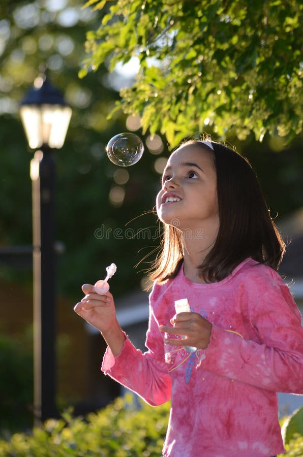 Little Girl Blows a Bubble and Marvels at it Stock Photo - Image of ...