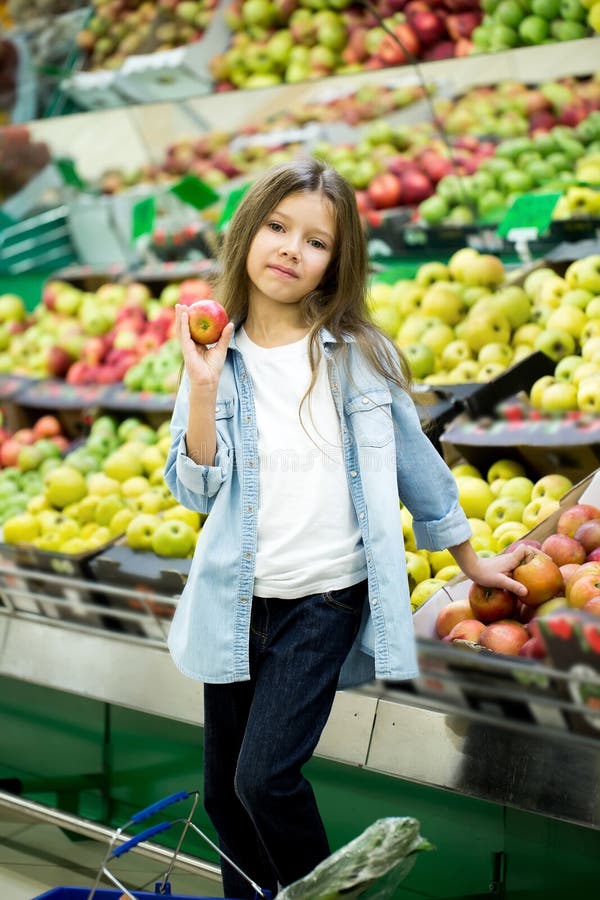 Little Girl Choosing a Bio Apple in a Store. Stock Image - Image of ...