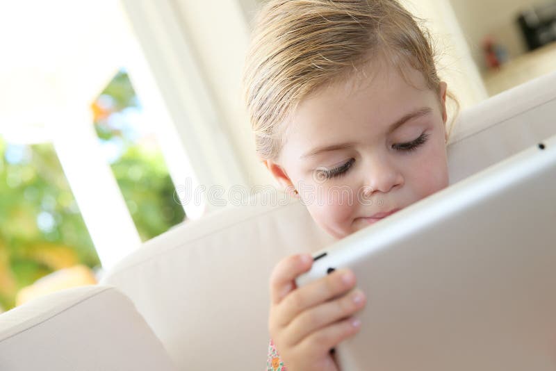 Little Girl Connected To Internet Using a Tablet Stock Image - Image of ...