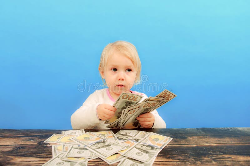 A Little Girl Counts Dollar Bills and Stacks Them Side by Side on the ...