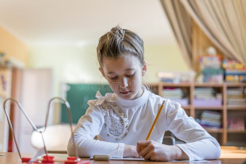 Little Girl at the Desk is Writing Stock Photo - Image of indoors ...