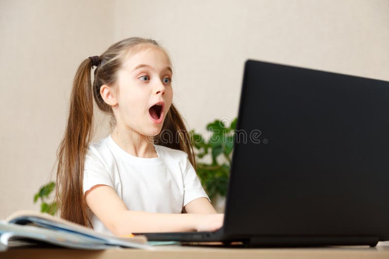 Little Girl Doing Her Homework at Home and Using a Laptop Stock Photo ...
