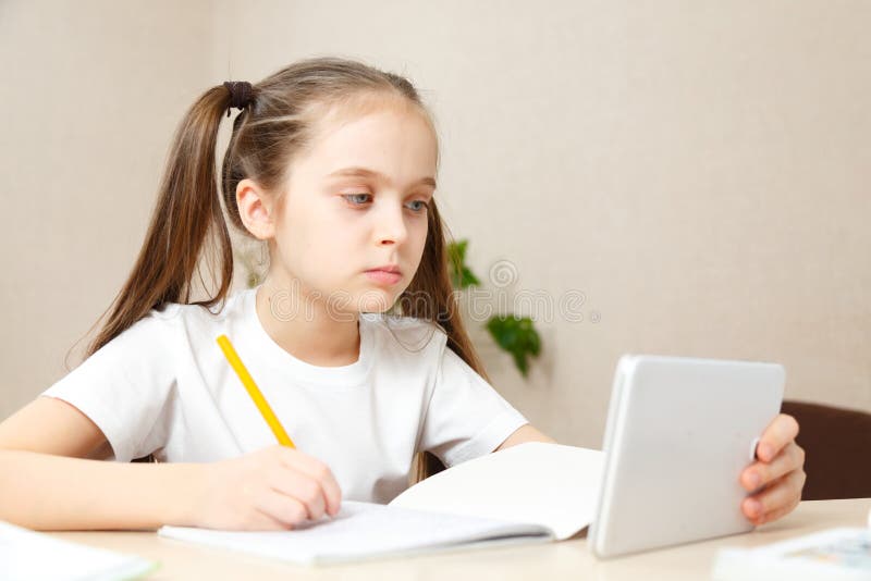 Little Girl Doing Homework at Home at the Table. the Child is Home ...