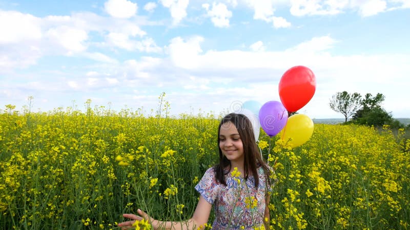 Little Girl in a Dress Running through Yellow Wheat Field with Balloons ... Little Girl in a Dress Running through Yellow Wheat Field with Balloons ...