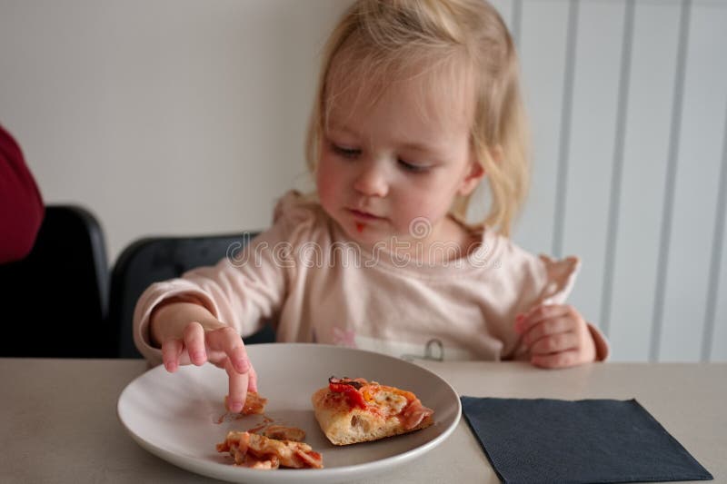 Little girl eating pizza stock photo. Image of face - 375131032