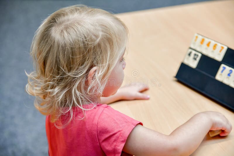 A Little Girl in Elementary School Learns Numbers and Puts Chips in ...