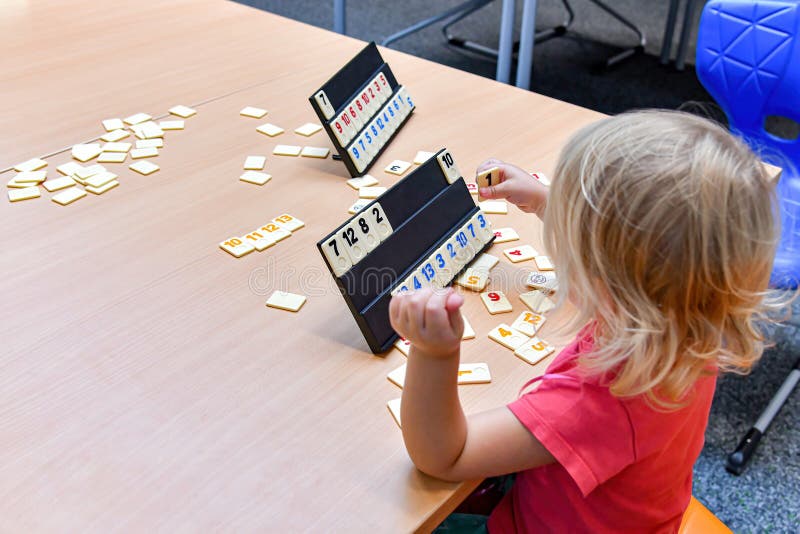 A Little Girl in Elementary School Learns Numbers and Puts Chips in ...