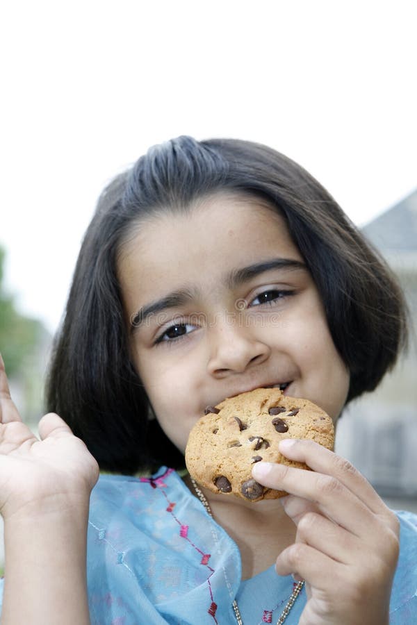 Little Girl Enjoying Cookie Stock Photo - Image of cookie, salwar: 5726442