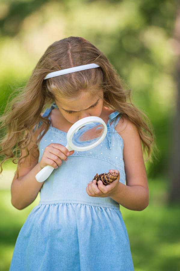 Little Girl Exploring the Cone through the Magnifying Glass Stock Photo ...