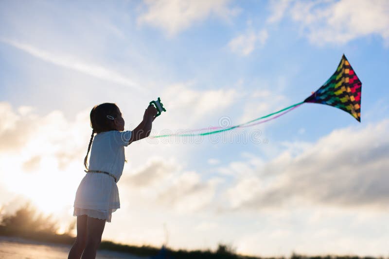 Little girl flying a kite stock photo. Image of silhouette - 38648582