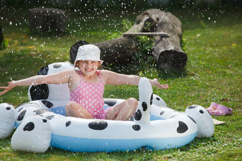 Little girl in garden pool stock photo. Image of dress - 15199644