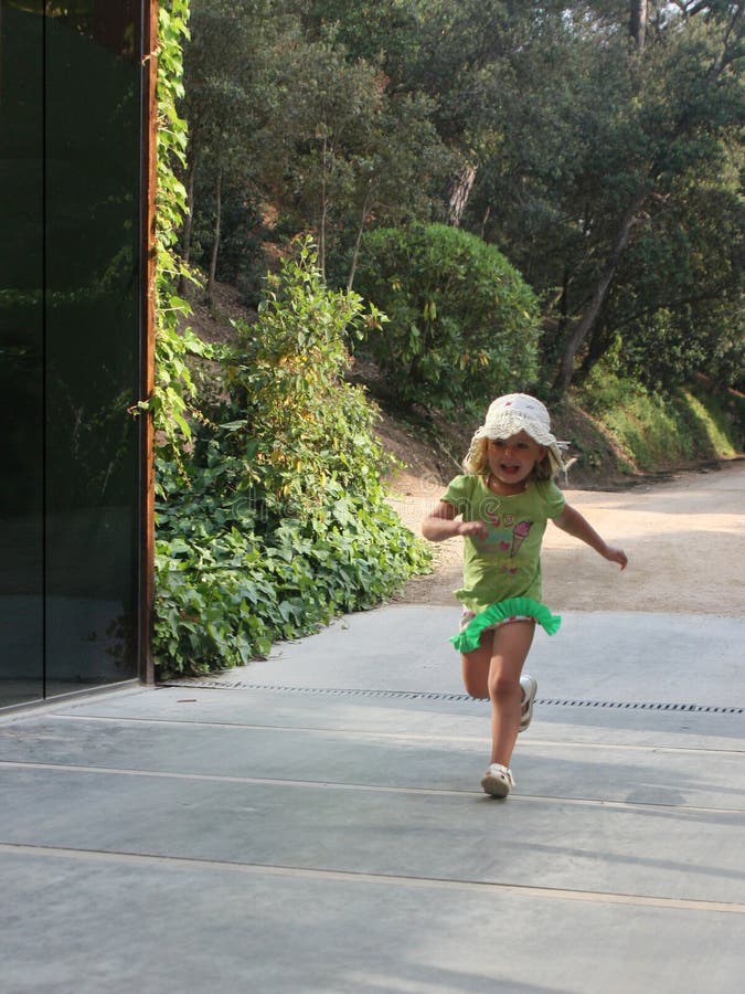 Little Girl Happily Running Along the Path from the Garden Stock Photo ...